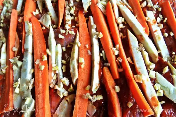 Sit afwisselende wortels en seldery, knoffel bo-op.