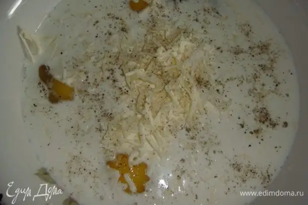 Despeje a crema nunha cunca profunda, engade ovos, ralla o queixo procesado nun ralador fino, sal e pementa. Bater cun garfo.