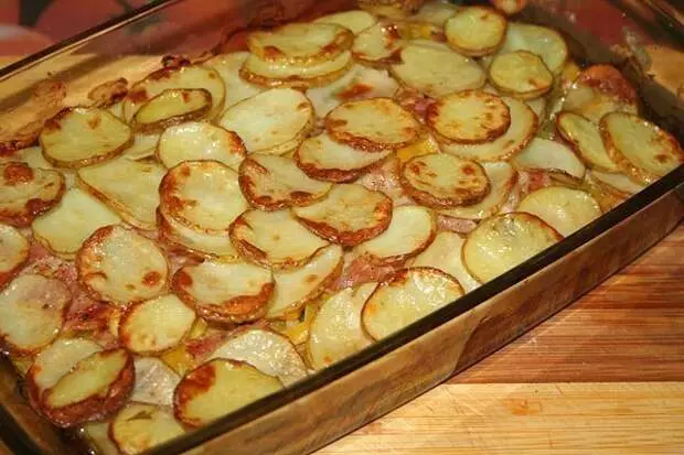 Baked young potatoes with bacon and vegetables