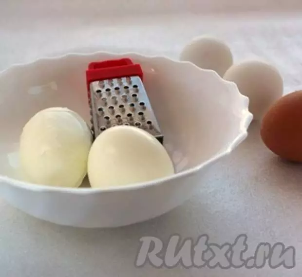 Boil eggs and grate on a coarse grater.