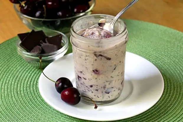 Farinha de aveia em uma jarra com cerejas e gotas de chocolate