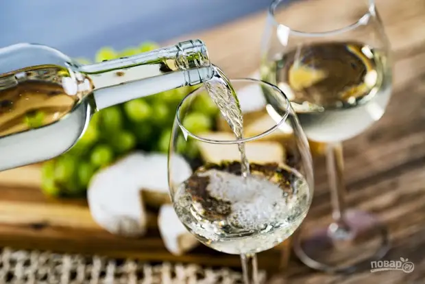 Το λευκό κρασί χύνεται σε ένα ποτήρι