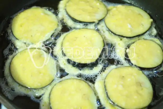 Doop plakjes aubergine in beslag en bak ze in een pan met plantaardige olie. Bak aan beide kanten.