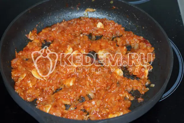 Voeg er fijngehakte tomaat, zout, peper en basilicum aan toe, 1 eetl. een lepel tomatenpuree, 1 teentje knoflook, in plakjes gesneden en 10 minuten sudderen op middelhoog vuur, af en toe roeren