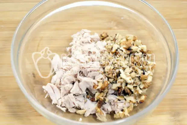 Комбинирайте ситно нарязаното пилешко филе и нарязаните орехи в купа