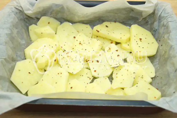 Couvrir le plat de cuisson avec du papier sulfurisé et graisser avec de l'huile, tapisser la couche de tranches de pommes de terre hachées, ajouter un peu de sel et de poivre.